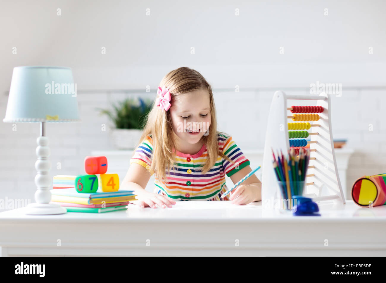 Child doing homework at home. Little girl with wooden colorful abacus ...