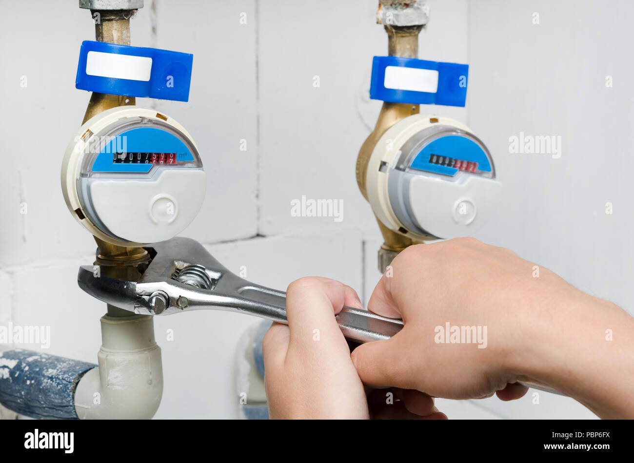 Technician installs a new water meter. Blue modern radio water counter ...