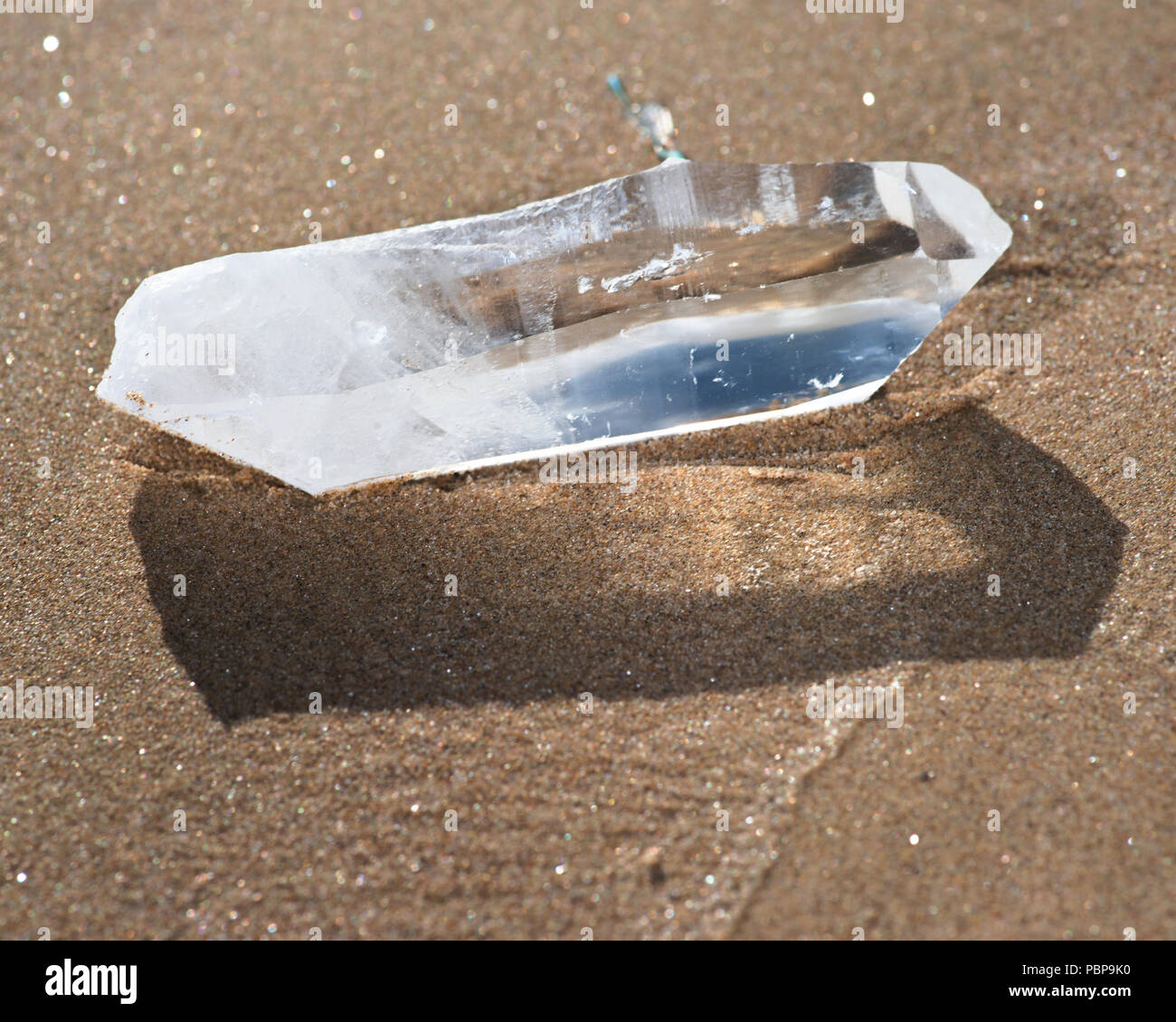 Himalayan Clear Quartz Point on wet sand near water on the beach at ...