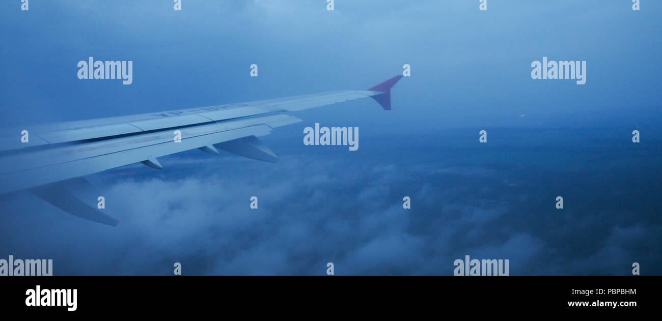 View of jet plane wing with cloud patterns in the fog Stock Photo - Alamy