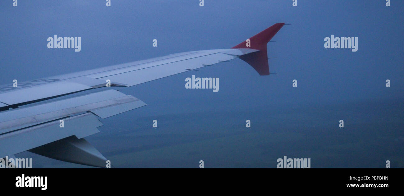 View of jet plane wing with cloud patterns in the fog Stock Photo - Alamy
