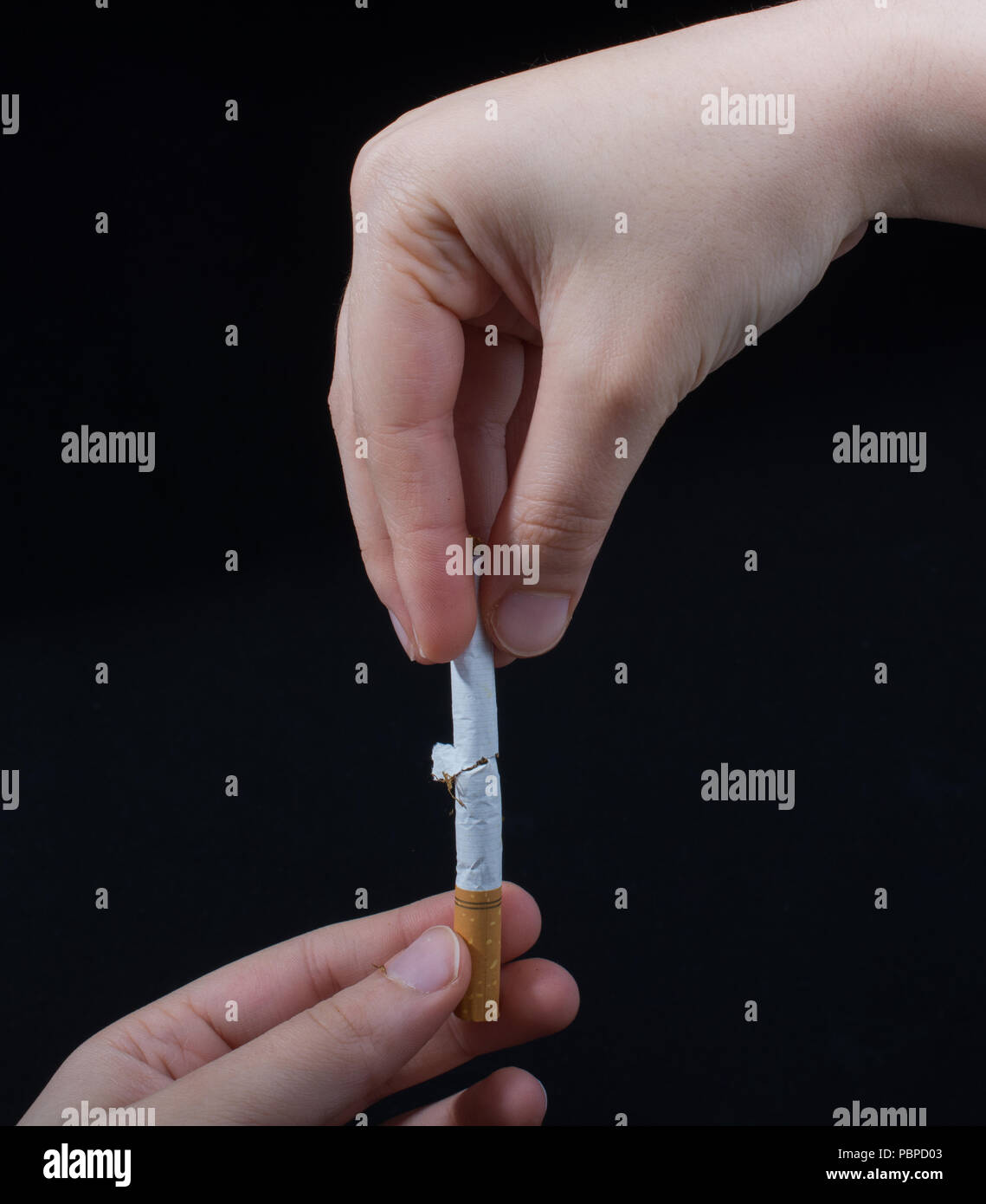 Hand is breaking a cigarette on a black background Stock Photo - Alamy