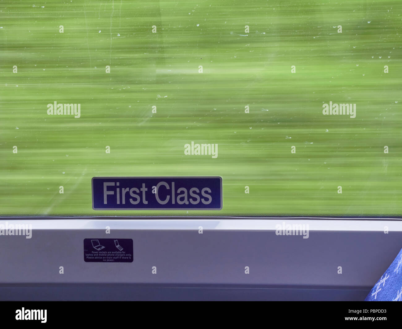 The First Class Carriage sign on a Moving Train with a blurred green ...