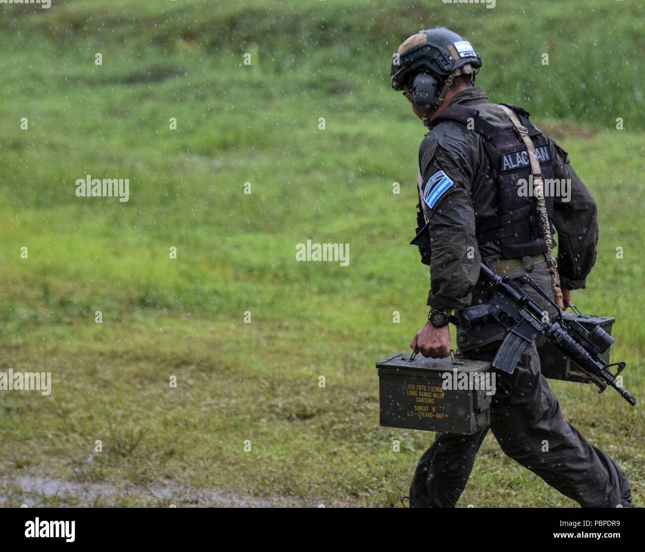 An Argentinian comando runs with ammo cans during a stress shoot as ...