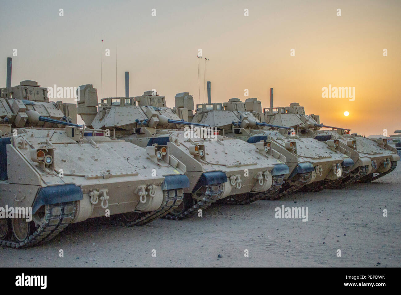 Four M2A3 Bradley Infantry Fighting Vehicles are illuminated by the ...
