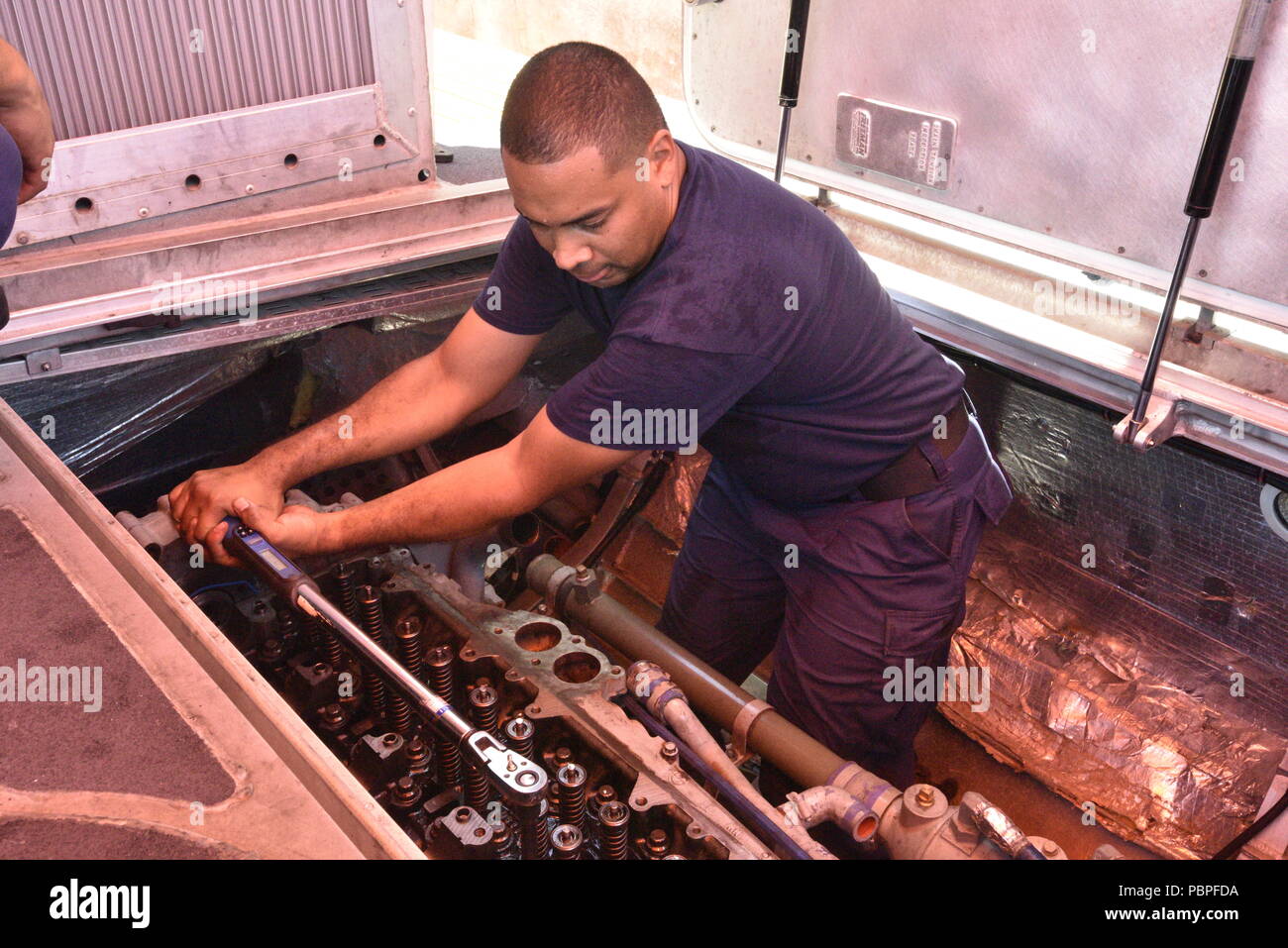 Petty Officer 1st Class Christopher Cordero torques a bolt on a Coast ...
