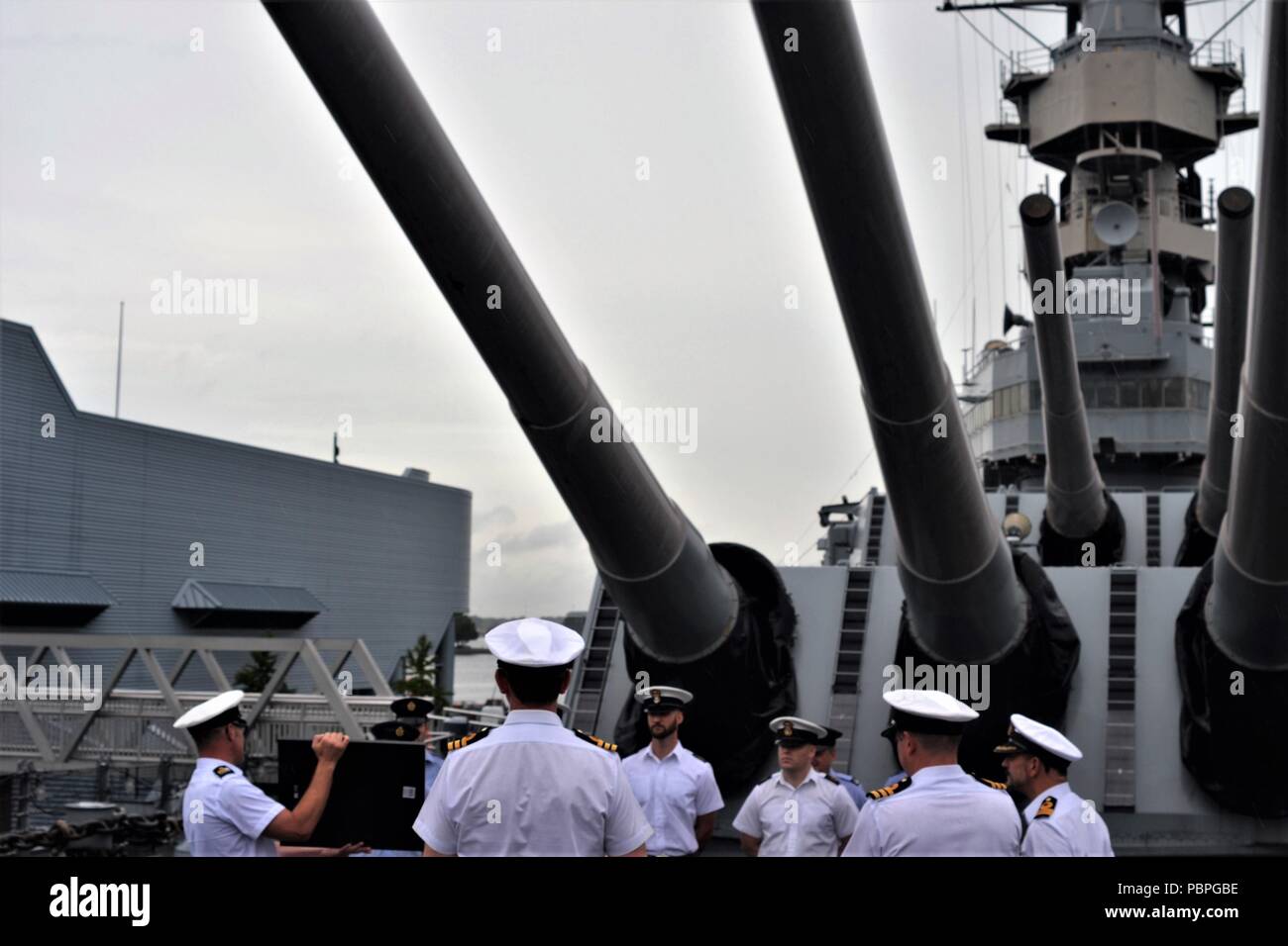 Service members with the UK Royal Navy are pictured in-front of turret ...