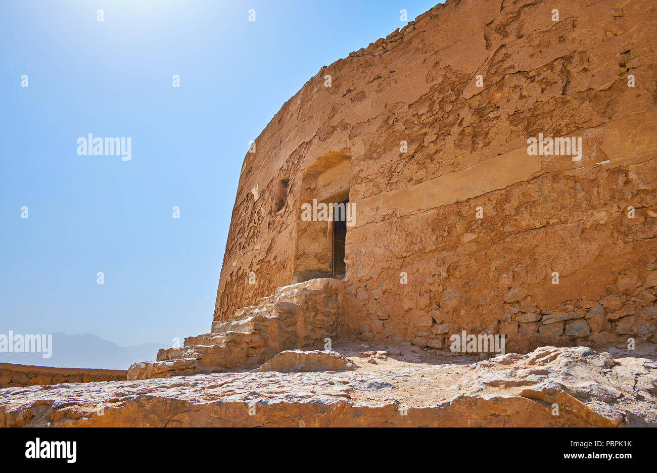 The huge wall of stone and clay with small door, leading inside the ...
