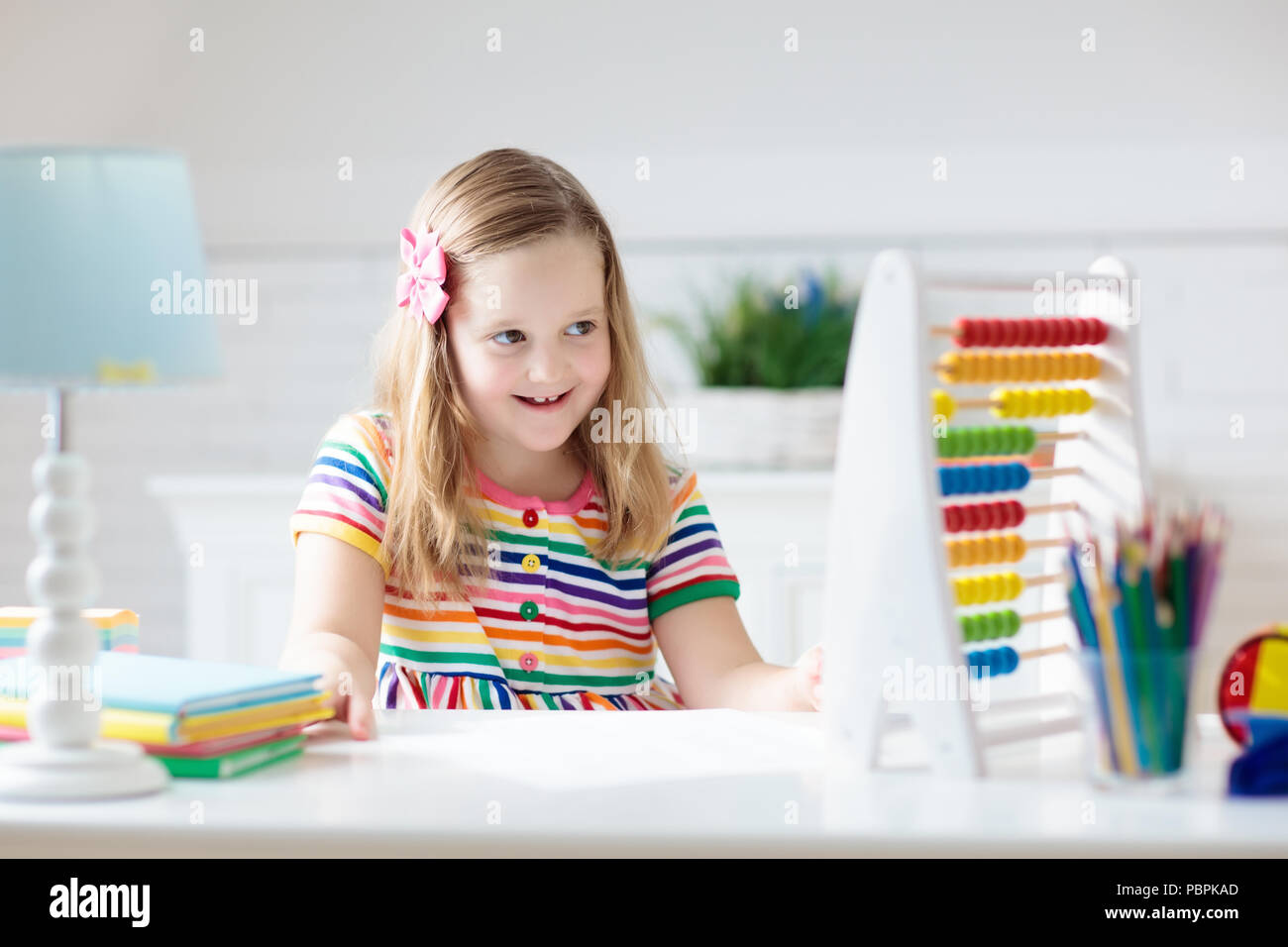 Child doing homework at home. Little girl with wooden colorful abacus ...
