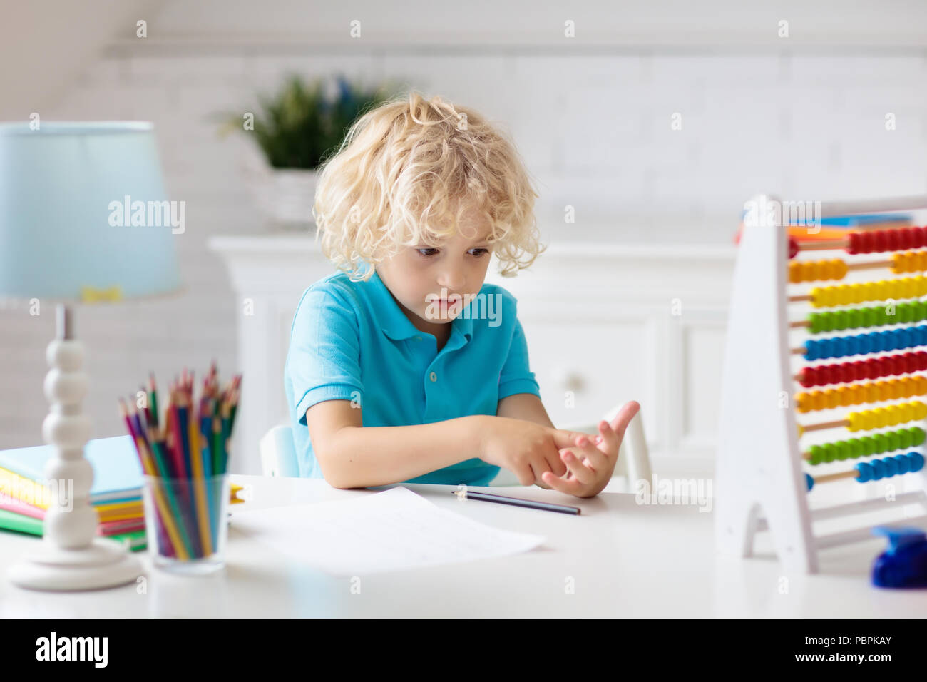 Child doing homework at home. Little boy with wooden colorful abacus ...