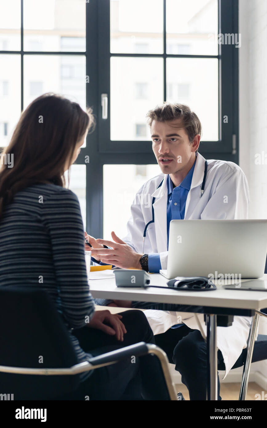 Young devoted doctor listening with attention to his patient Stock ...
