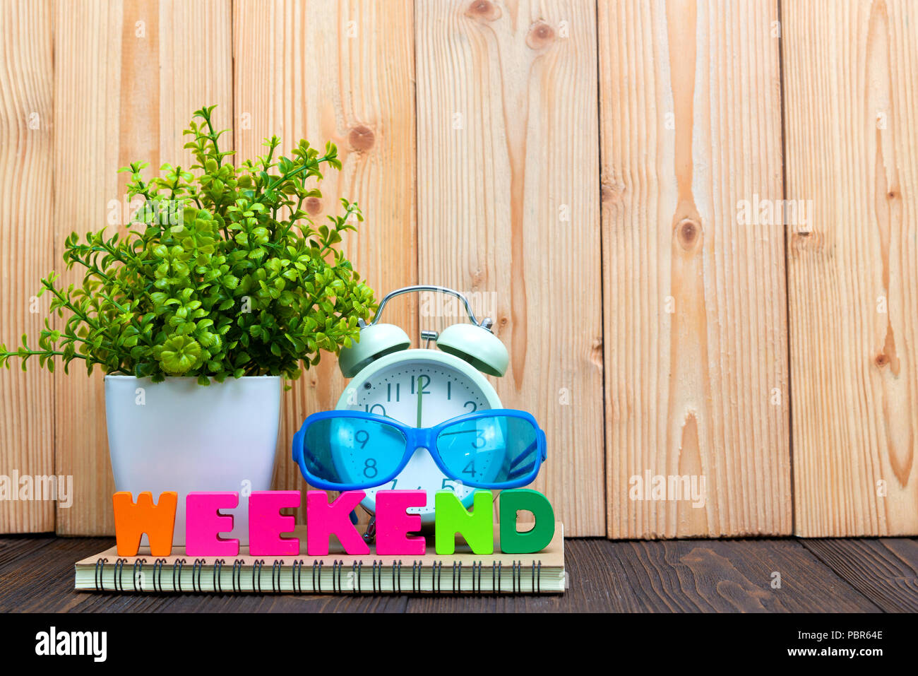 WEEKEND letters text and notebook paper, alarm clock and little ...