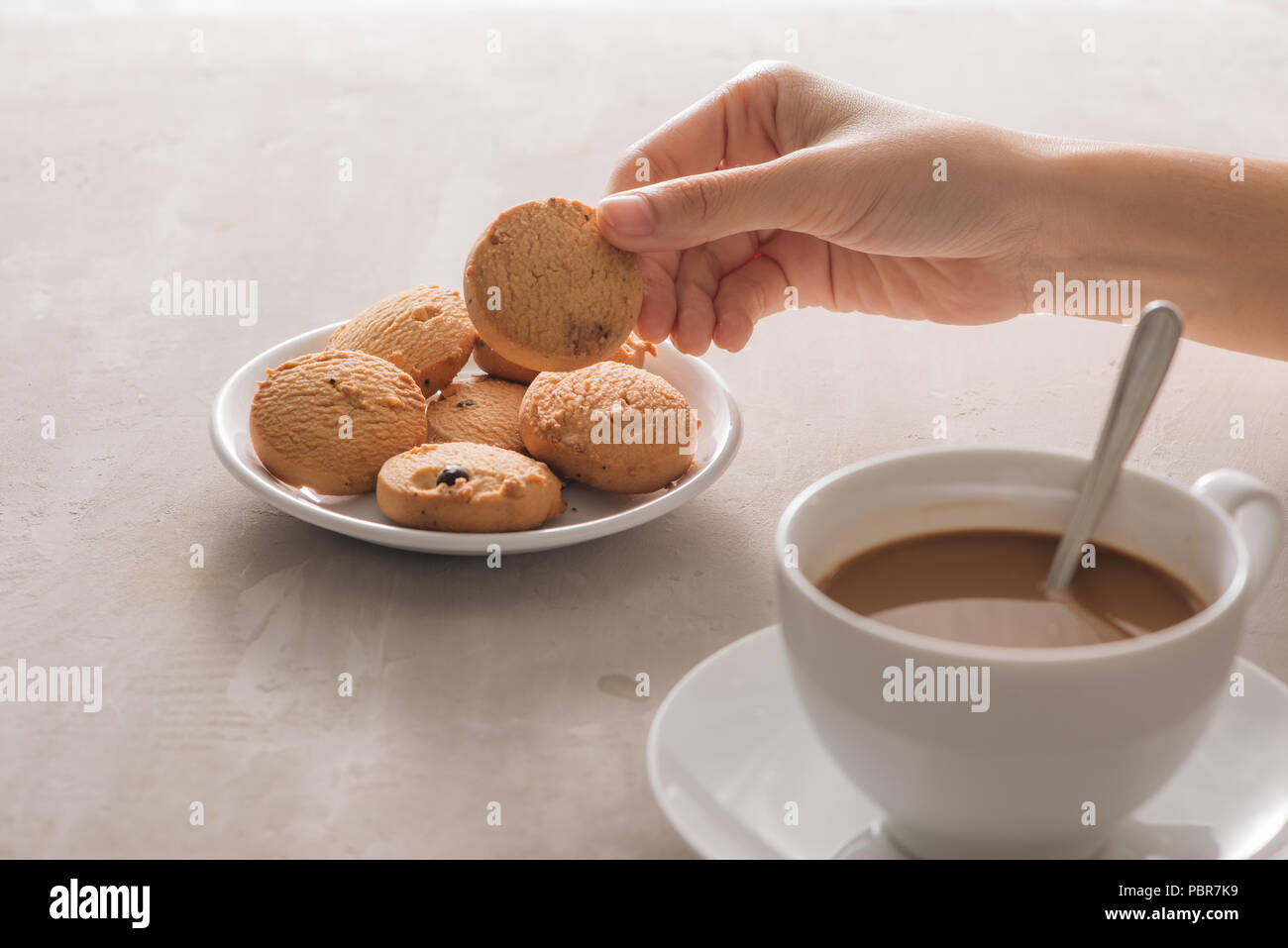 Hand picking cookie from plate. Drink with caffeine or cocoa with milk ...