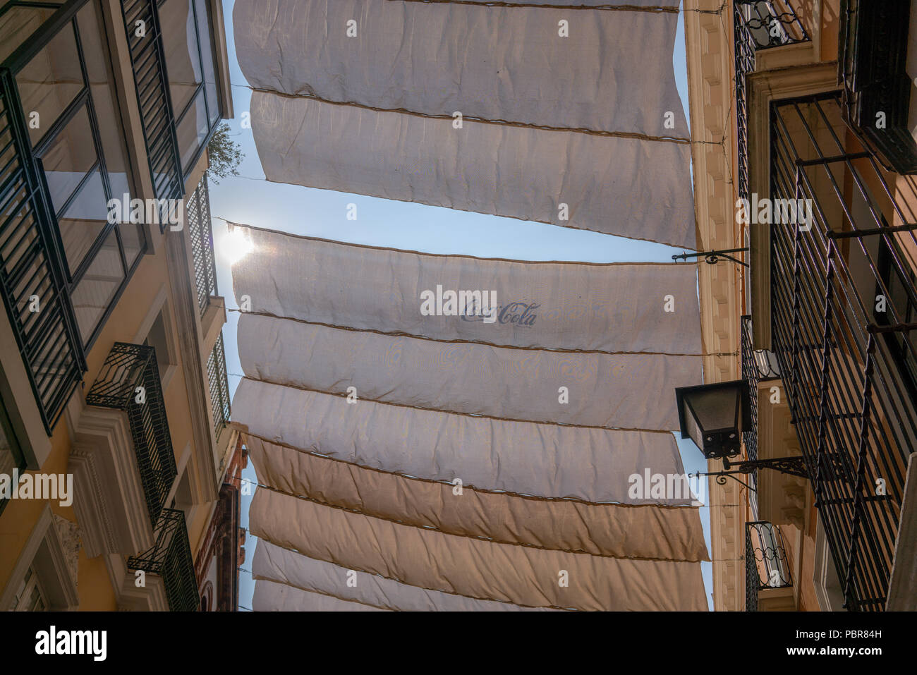 Sun canopies advertising Coca-Cola stretched over a Seville street in ...