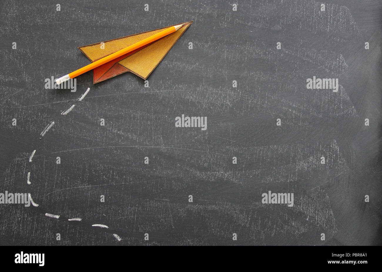 Top view image of paper plane and pencil over classroom blackboard ...