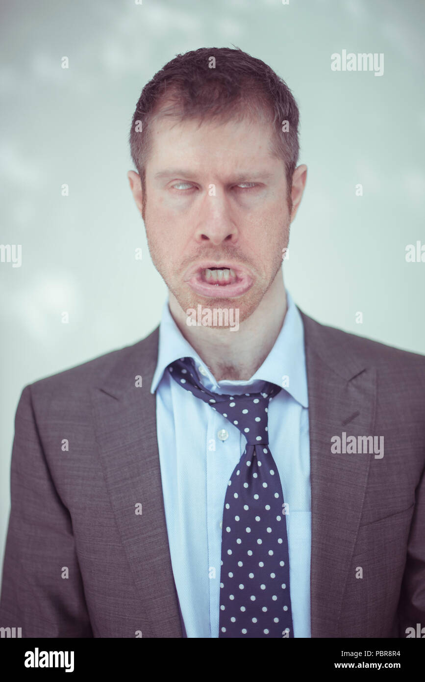 White man in a grey suit making a burned out face Stock Photo - Alamy