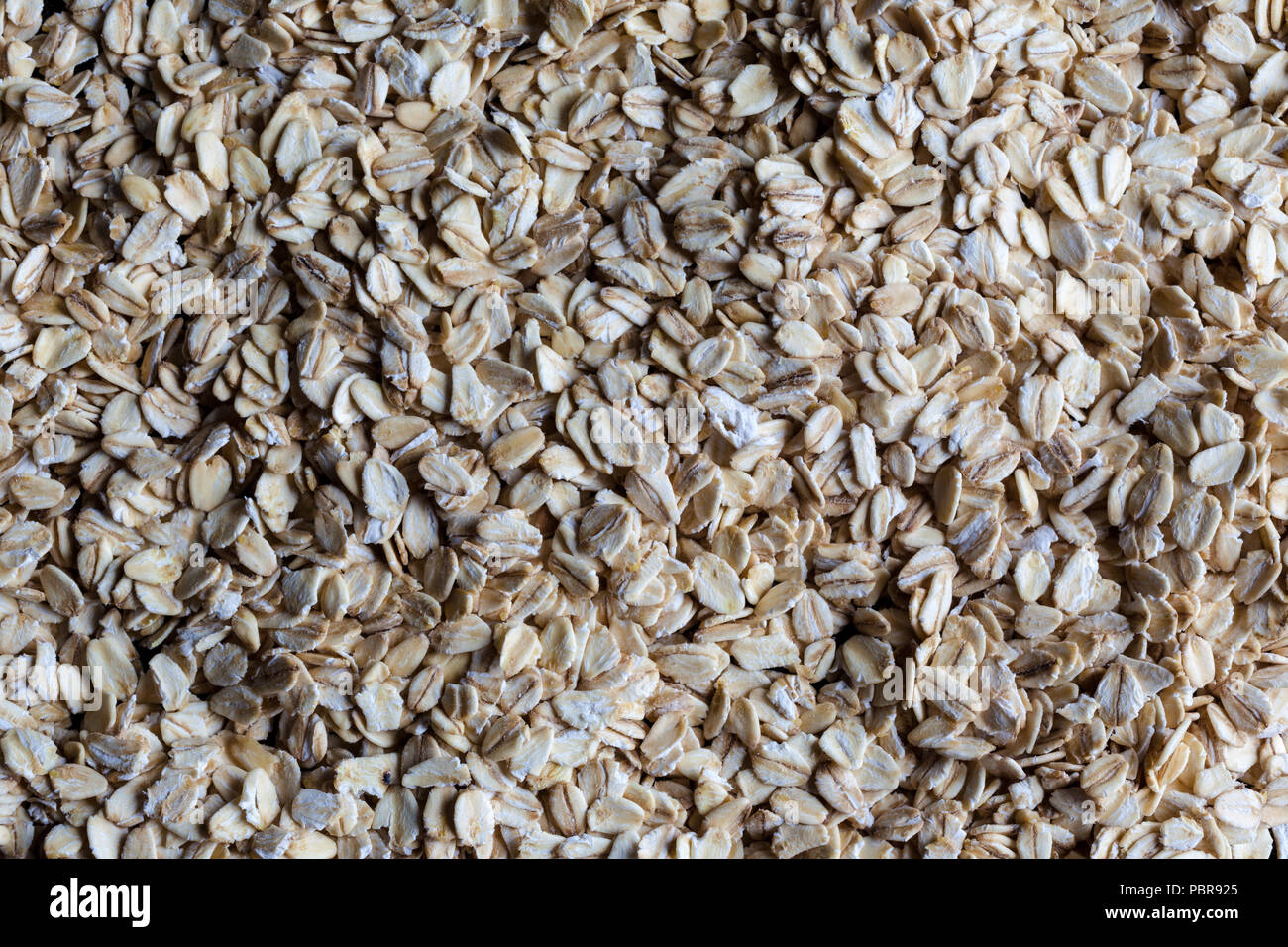 Oatmeal rolled oats grains spread evenly on surface directly from above ...