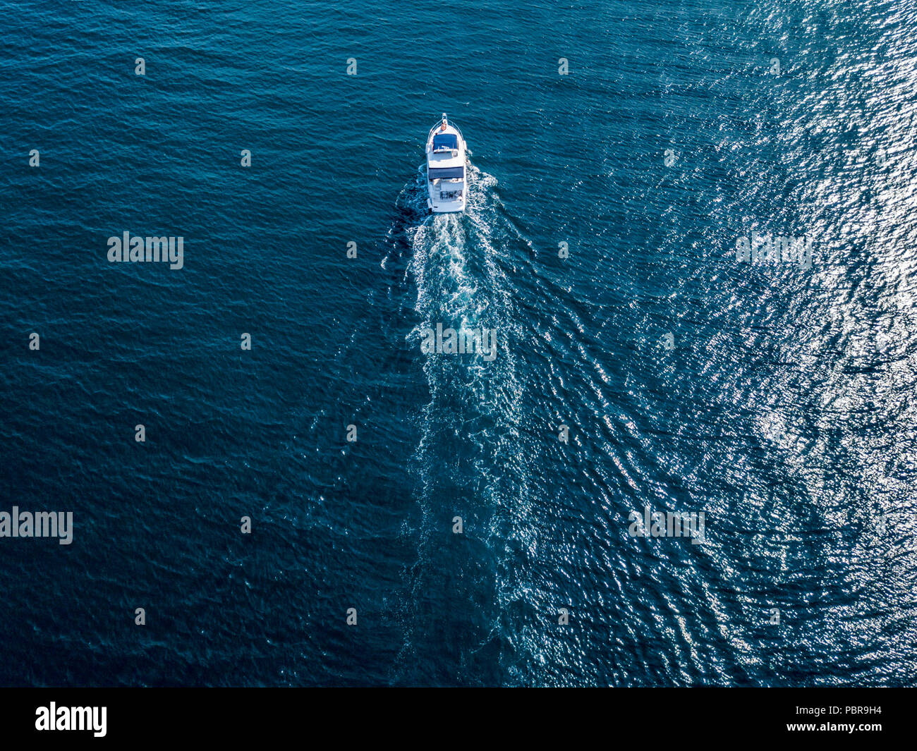 aerial top view of isolated fast speed white motor boat ship on a sea ...