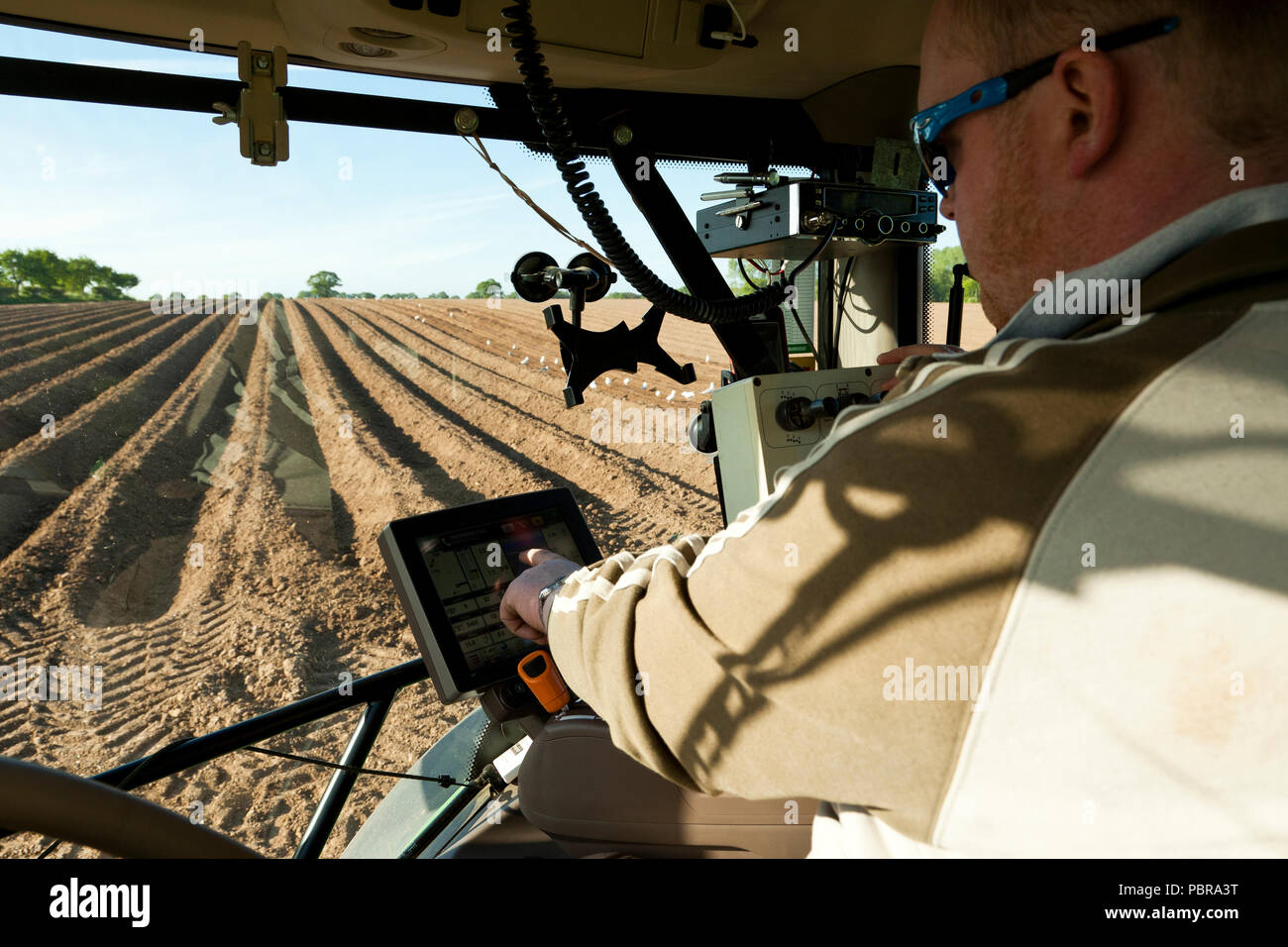 A farmer operating an on board computer inside a tractor cab Stock ...