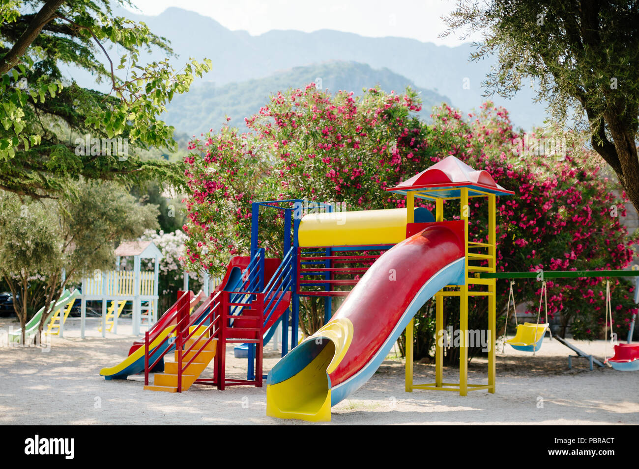 Children Playground in beautiful garden with mountains background Stock ...