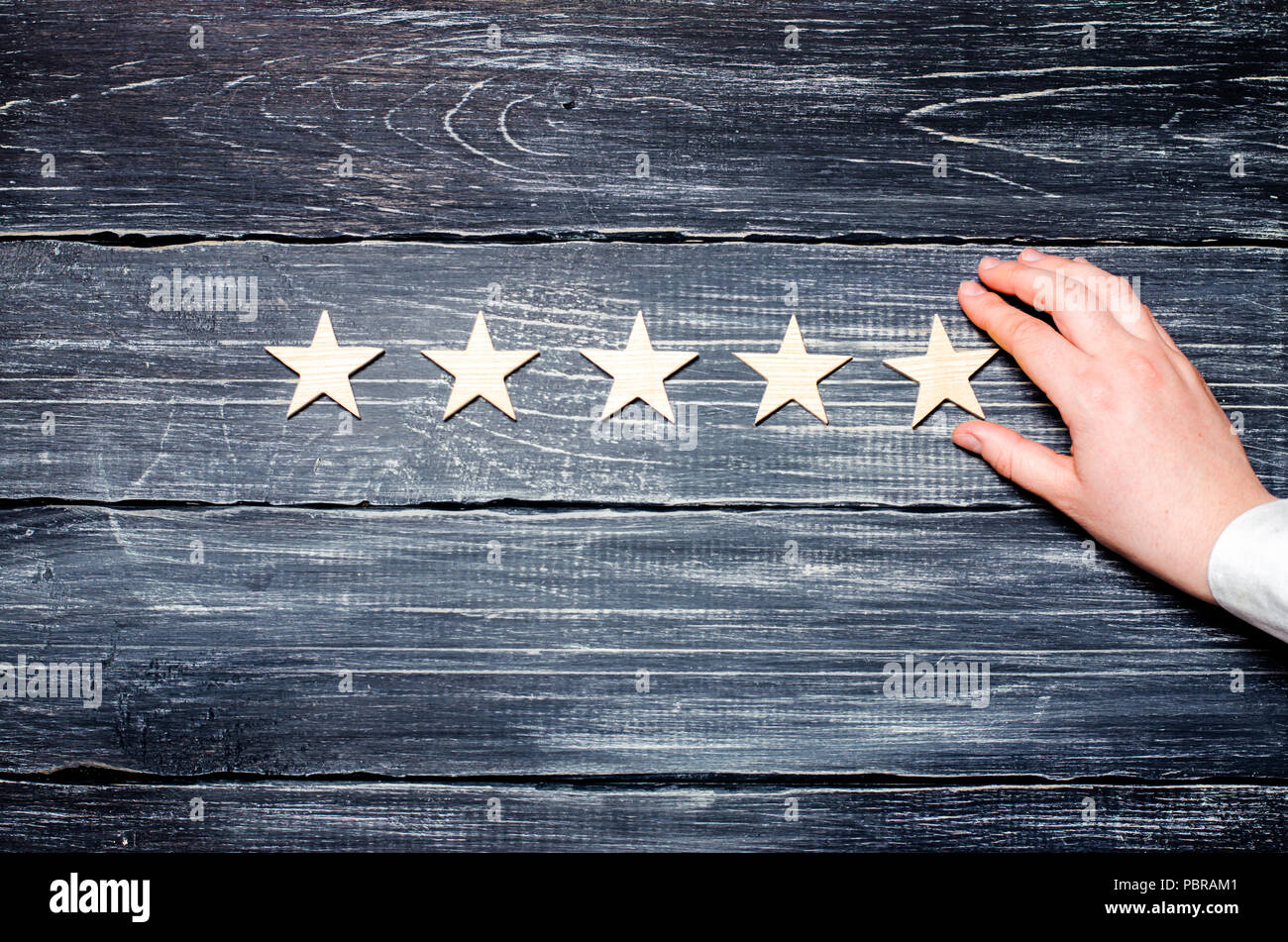 A woman's hand puts the fifth star. Quality status is five stars. A new ...