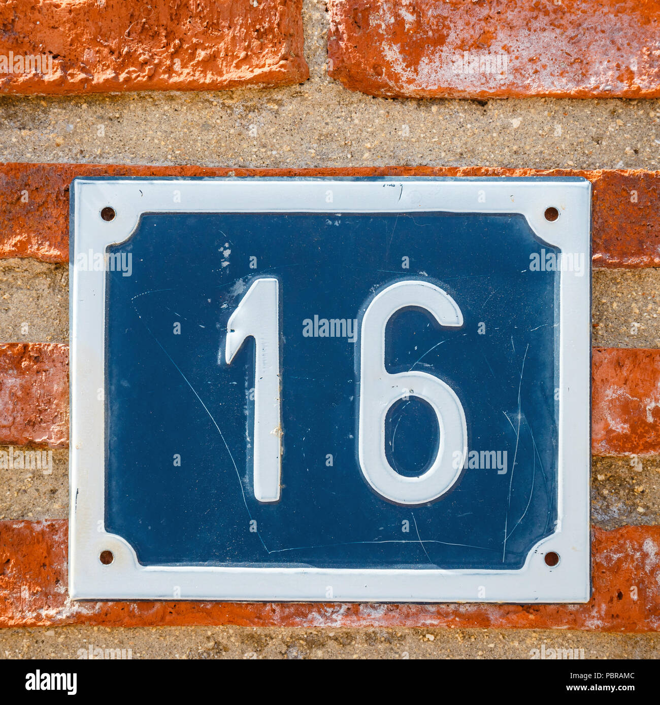 Number sixteen on a wall in a house, detail of a wall with a figure on ...