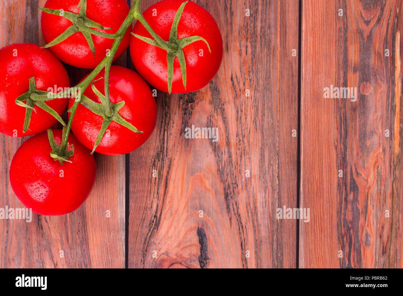 Fresh tomatoes in drops of dew. Top view. Wooden desk table background ...