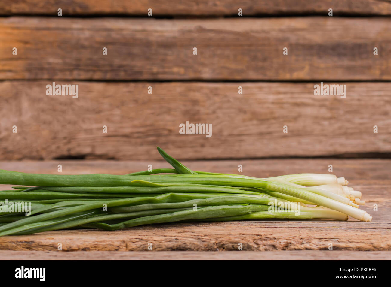 Fresh green onion in a bunch. Old rustic wooden table background Stock ...