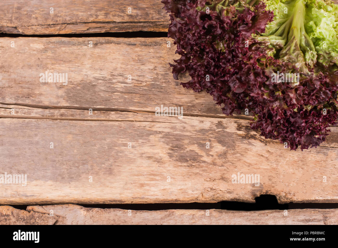 Leafy purple lettuce and copyspace. Top view. Old rustic wooden table ...