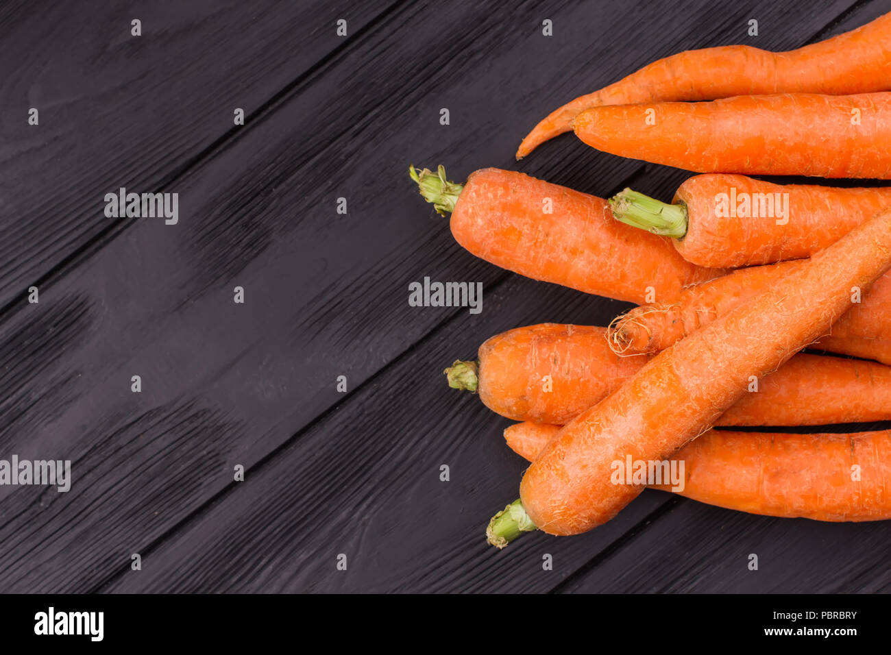 Pile of fresh clean carrots. Dark black wooden desk backgorund Stock ...
