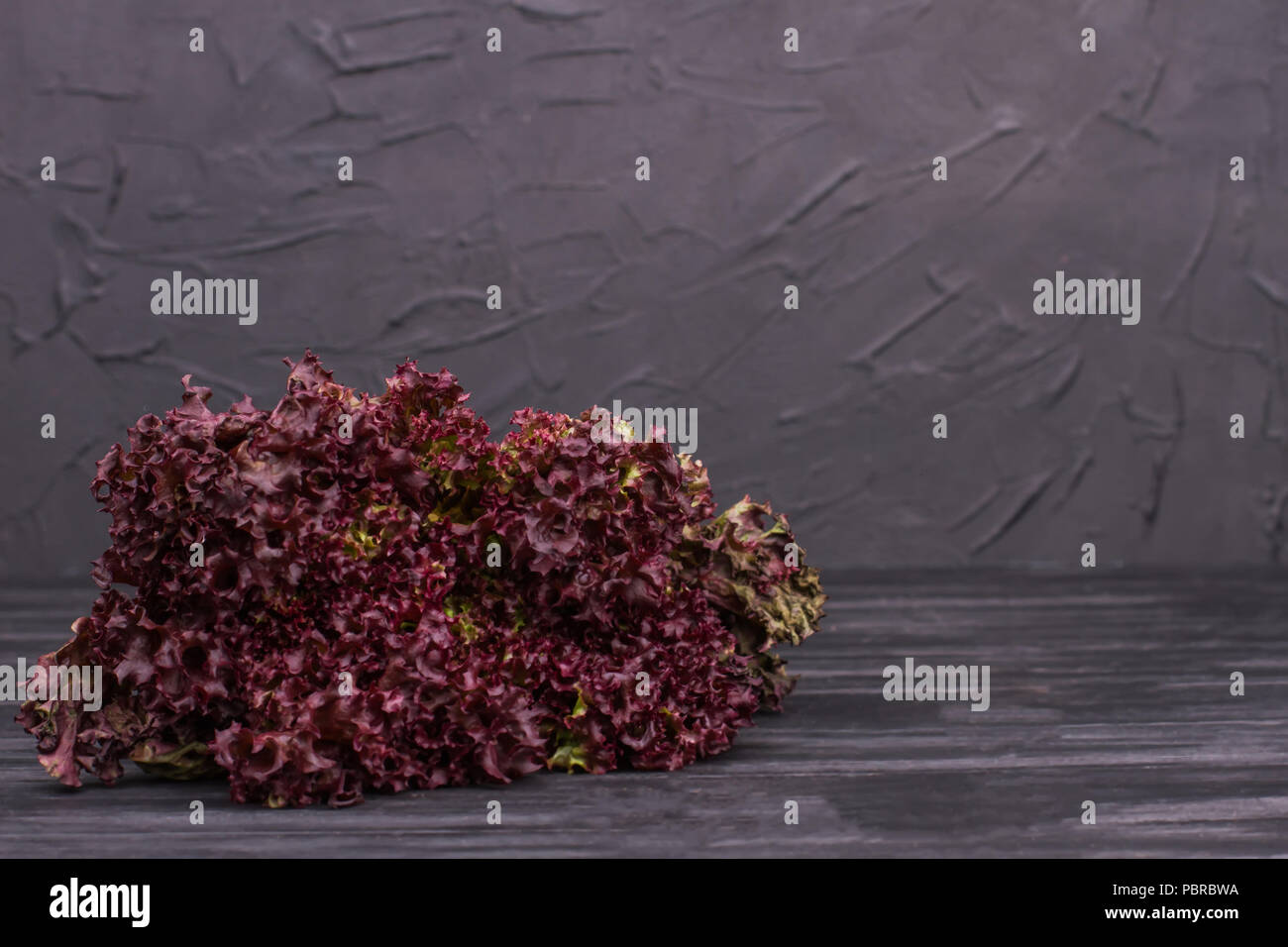 Red Curly Lettuce Leaves. Dark wooden background Stock Photo - Alamy