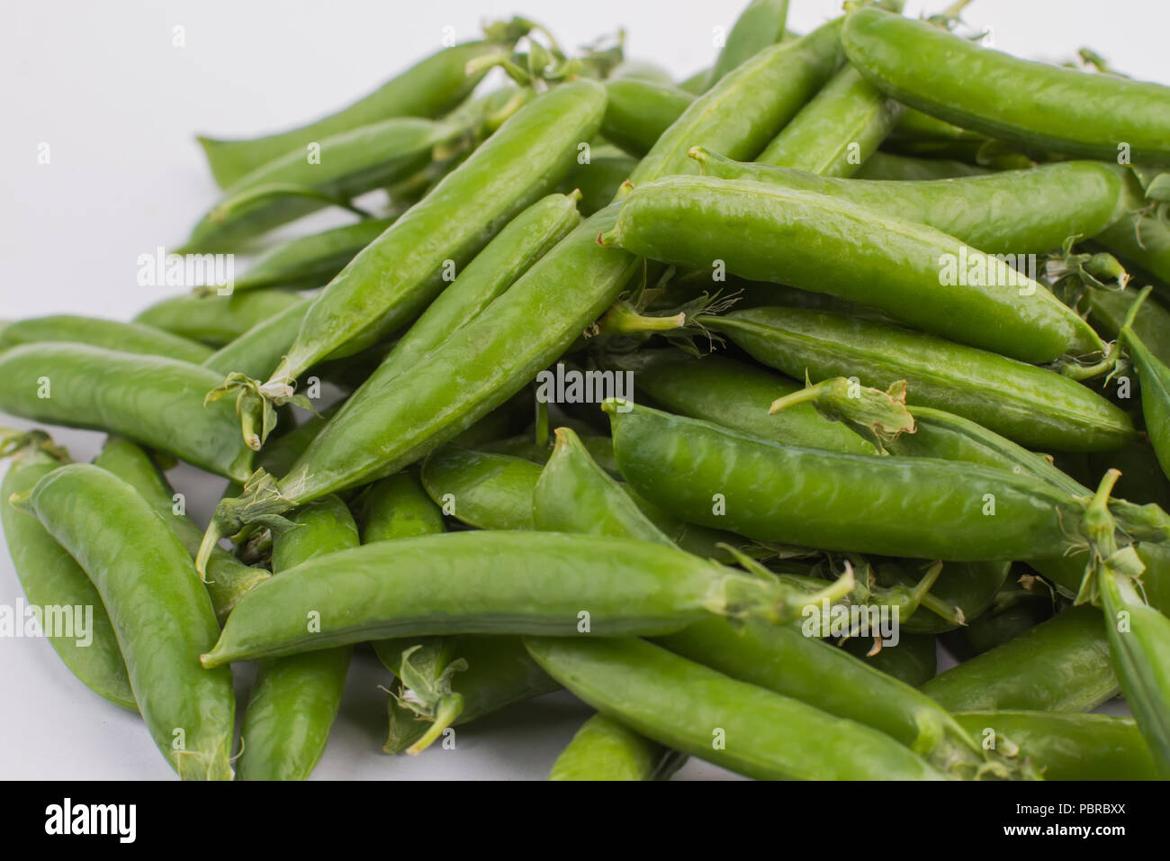 Fresh green peas, close up. White isolated background Stock Photo - Alamy