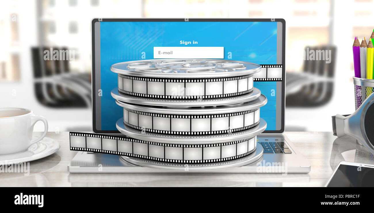 Cinematography concept. Film movie reels on a laptop in a blurry office ...
