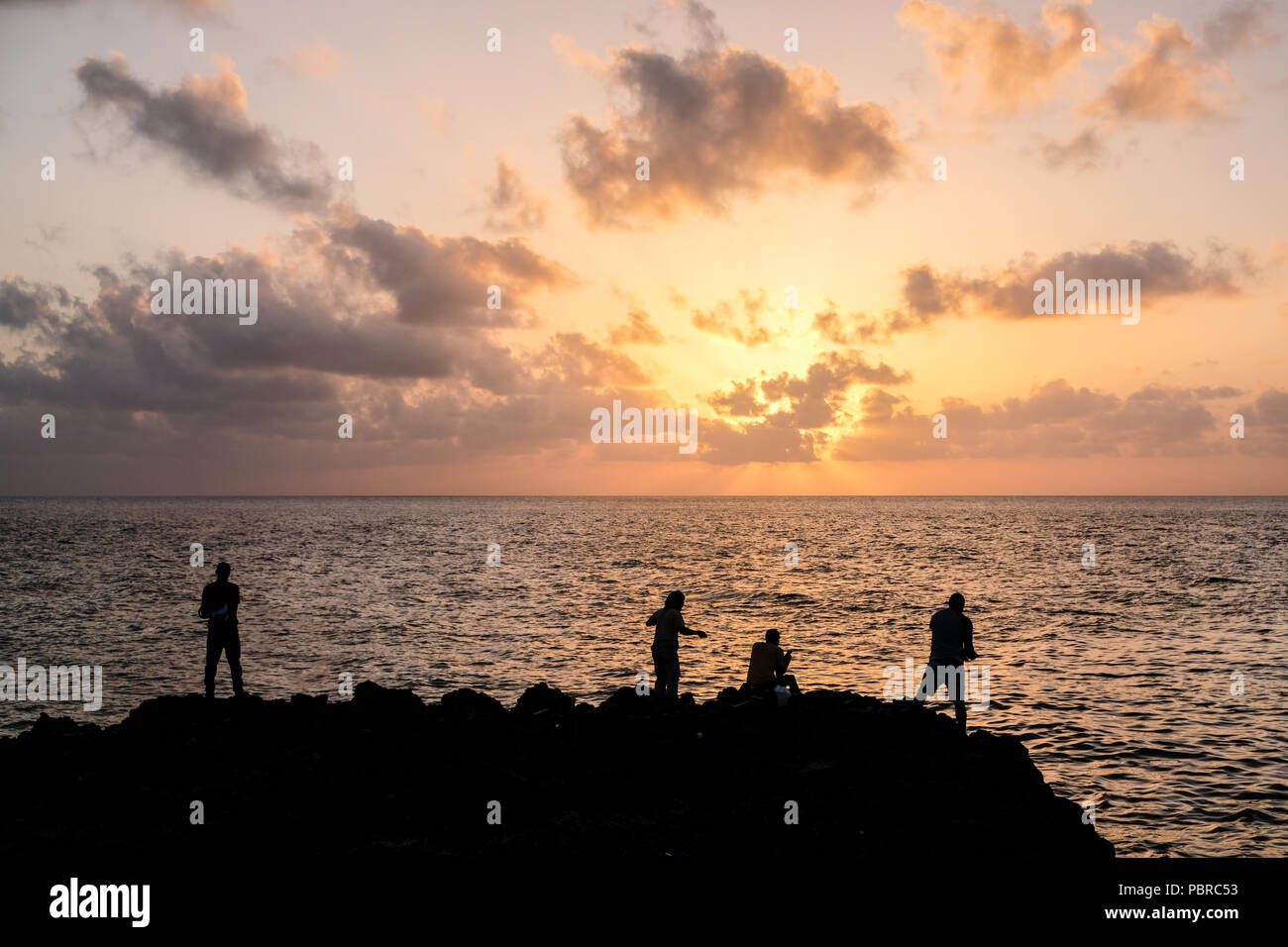 Caymanians people fishing from shore at sunset Cayman Island Stock ...