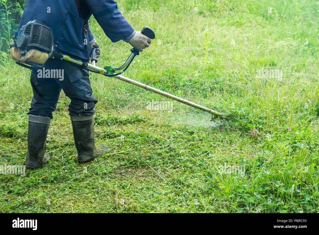 The gardener cutting grass by lawn mower Stock Photo - Alamy