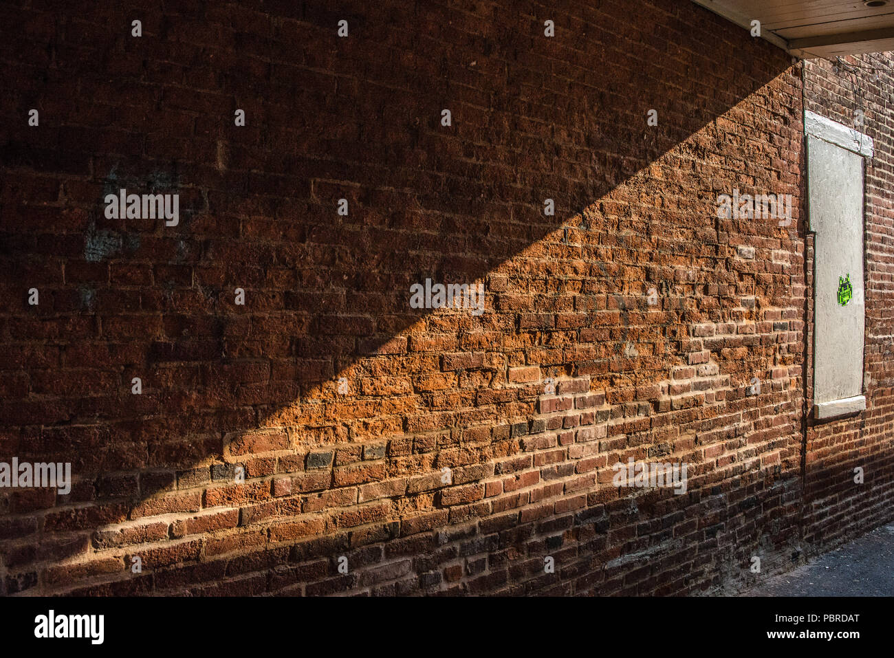 Back alley brick wall shadow patterns Stock Photo - Alamy