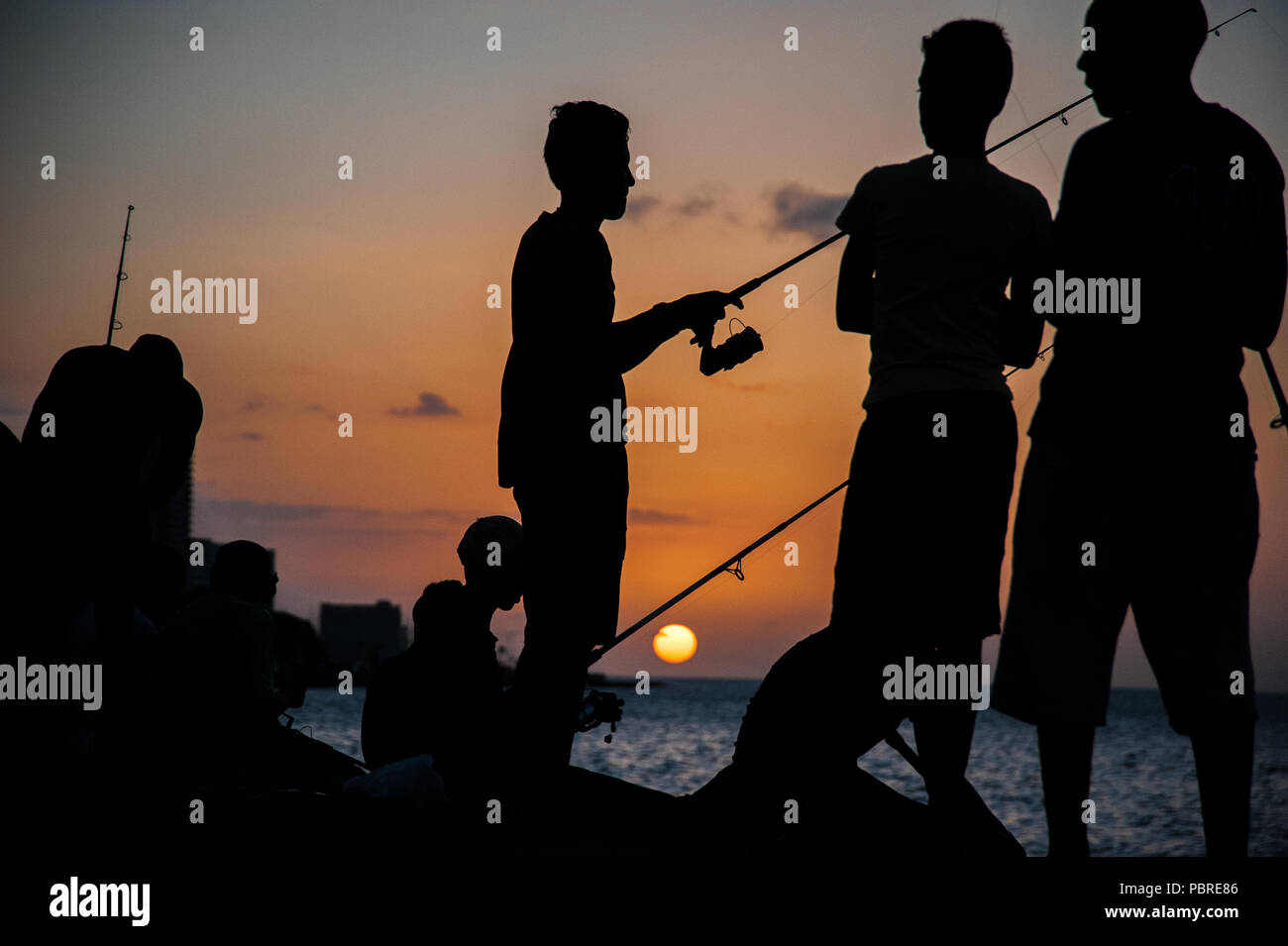 Cuban people fish at the malecon during the sunset,malecon is the ...