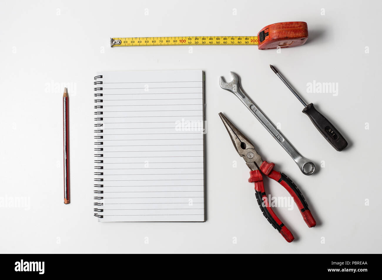 Tools with a note pad on white background Stock Photo - Alamy