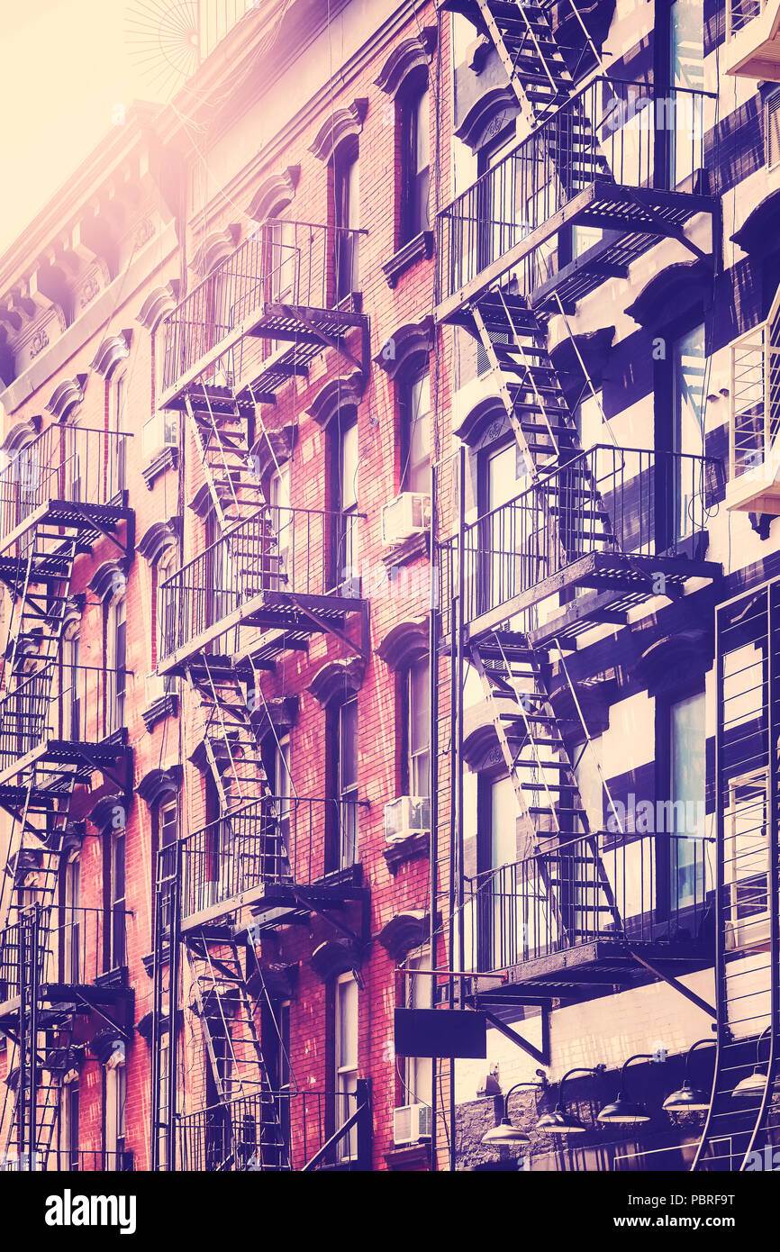 Retro toned picture of a building with fire escape ladders, New York ...