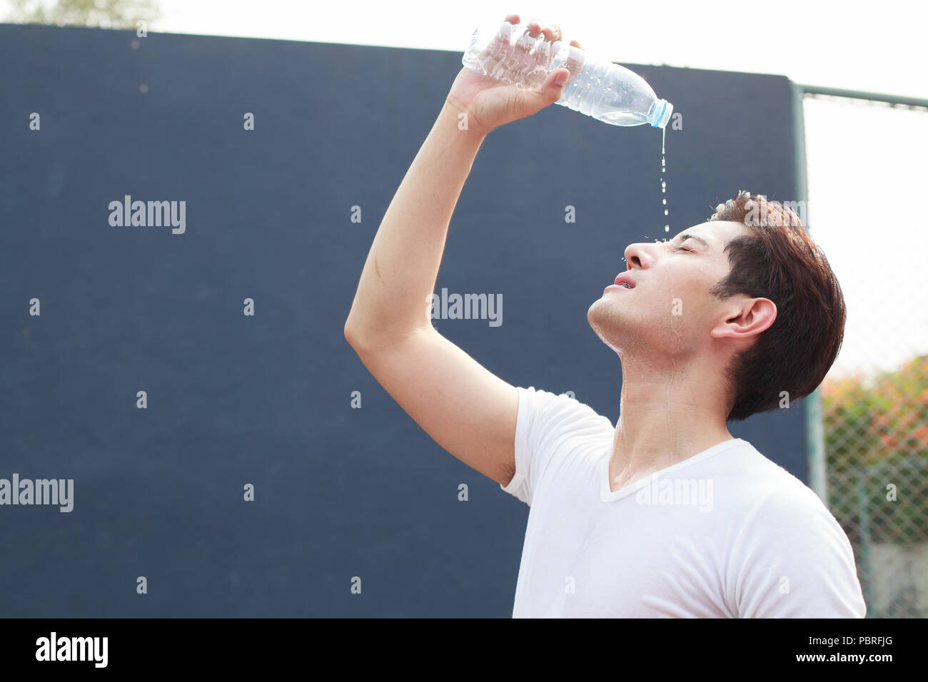 man pouring fresh mineral water drinking water from clean bottle over ...