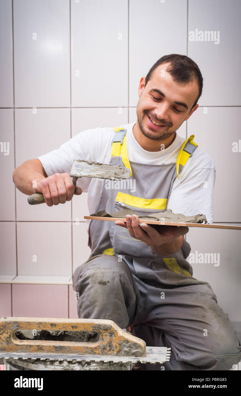 industrial tiler builder worker installing floor tile Stock Photo - Alamy