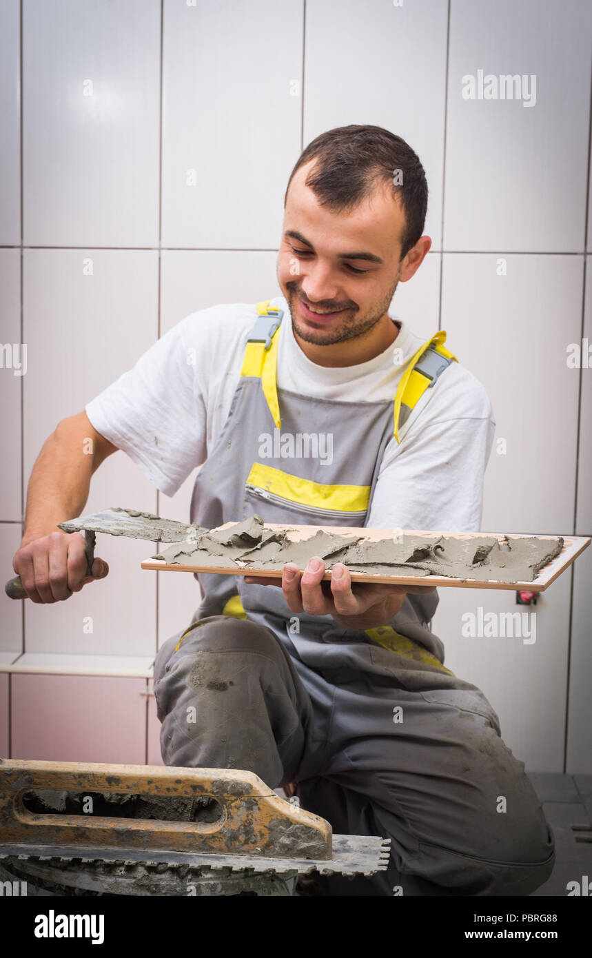 industrial tiler builder worker installing floor tile Stock Photo - Alamy