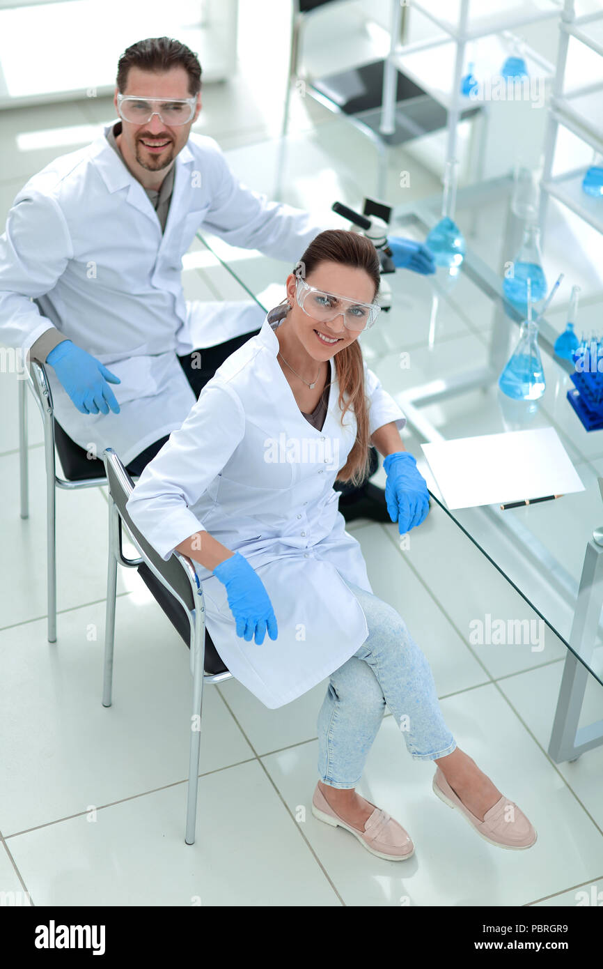 two positive scientists work sitting at a laboratory table Stock Photo ...