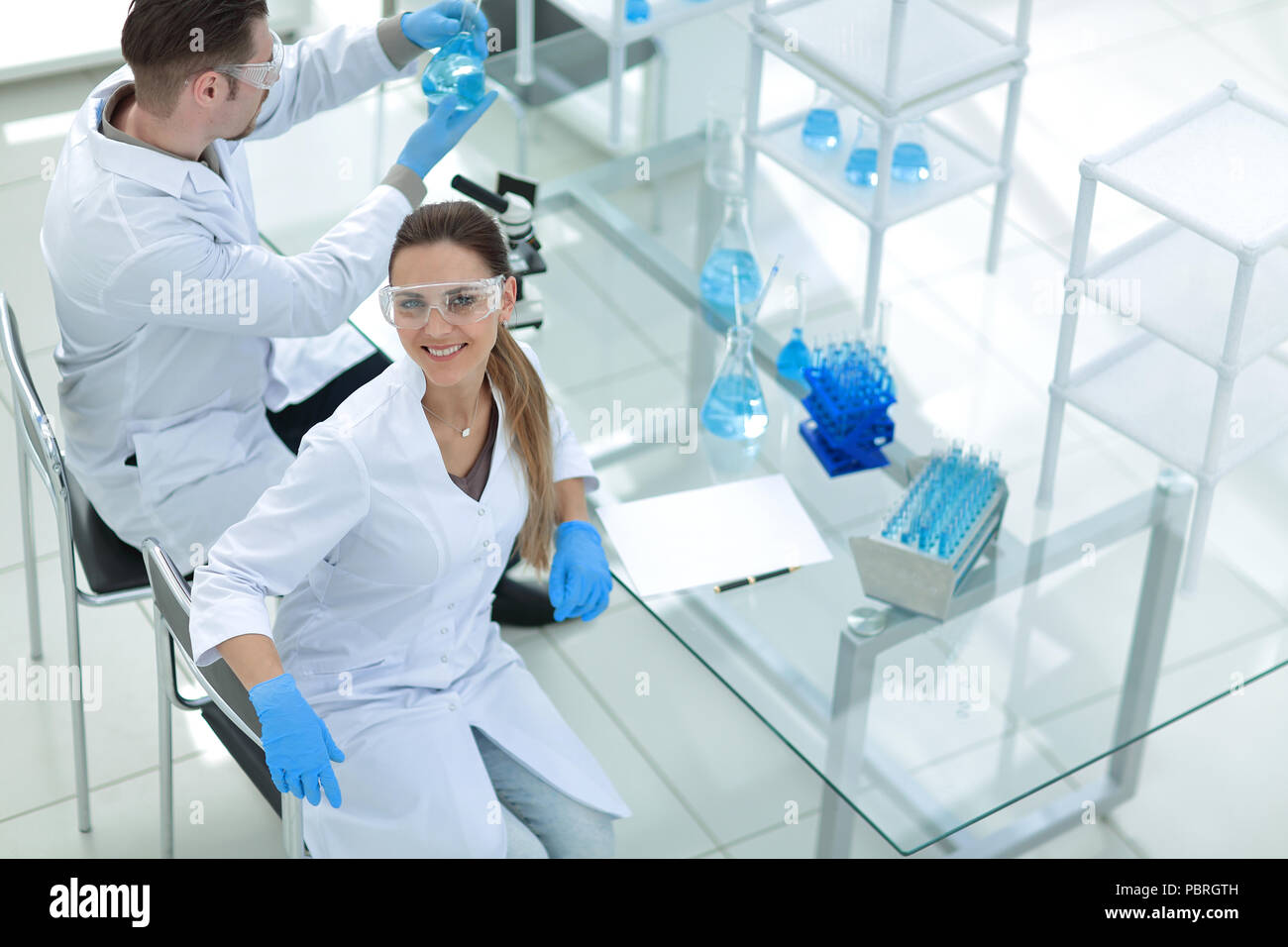 couple of successful lab techs sitting at their Desk Stock Photo - Alamy