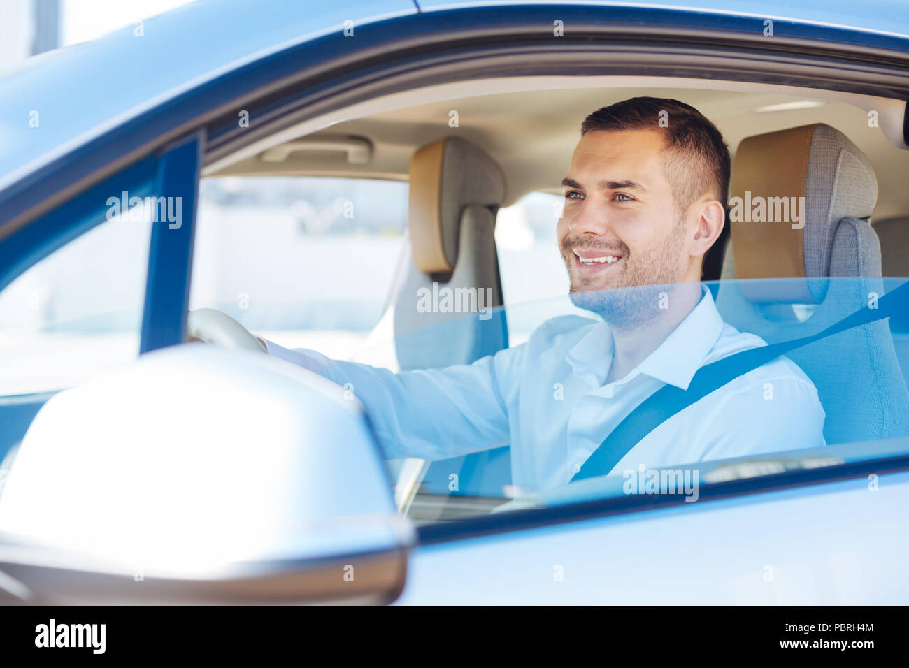 Positive nice taxi driver working Stock Photo - Alamy