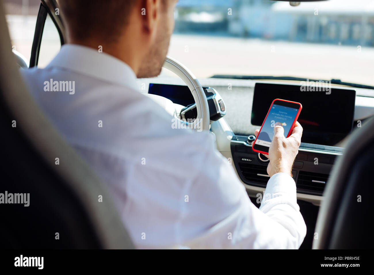Professional male driver using his smartphone Stock Photo - Alamy