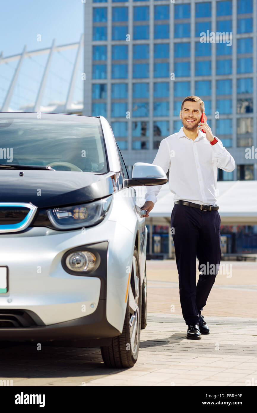 Positive smart man coming to his car Stock Photo - Alamy