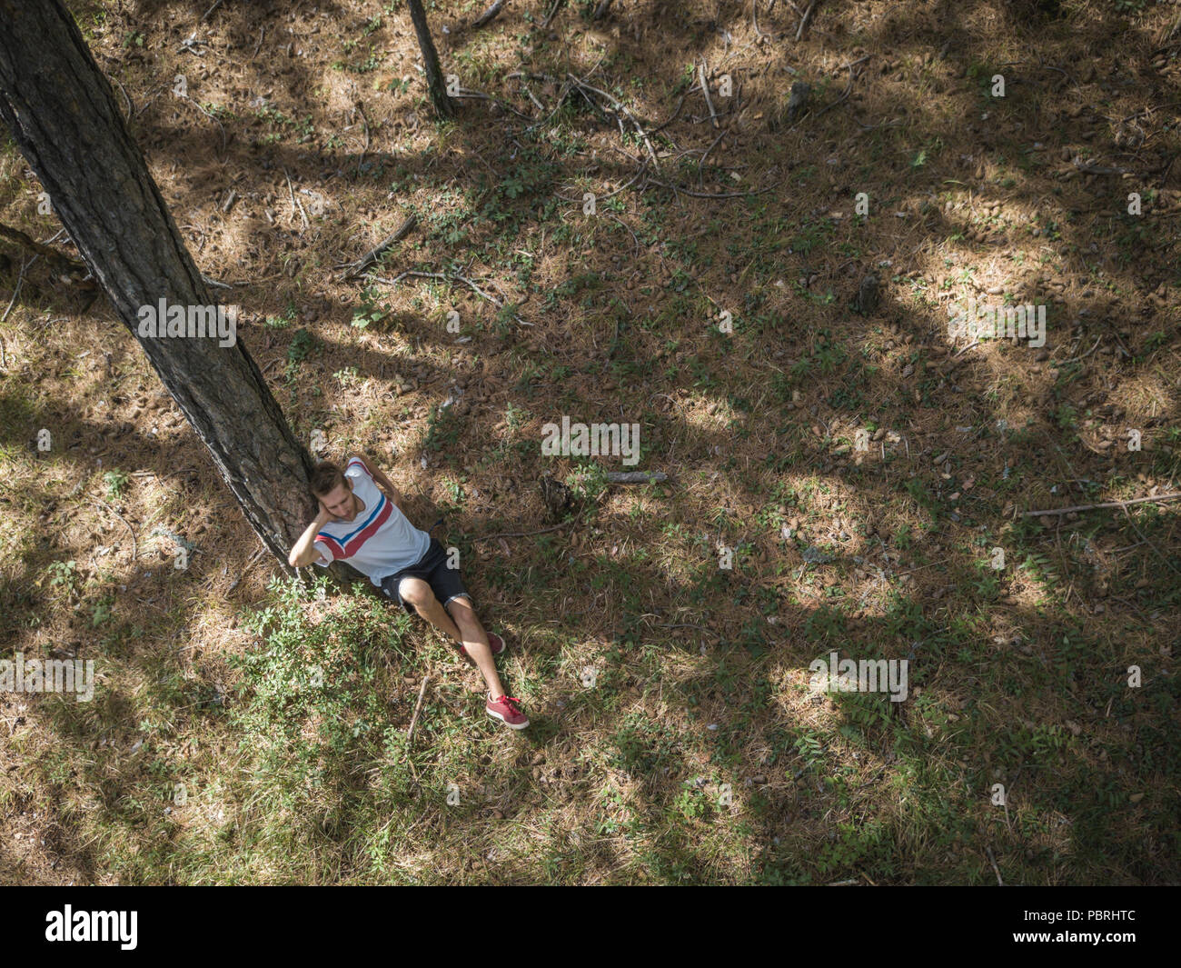 Man sitting alone under tree hi-res stock photography and images - Alamy