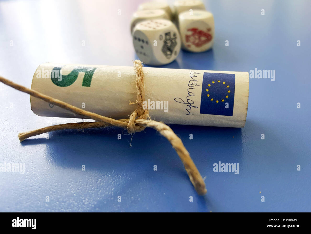 rolled euro banknote on a blue background,image of a Stock Photo - Alamy
