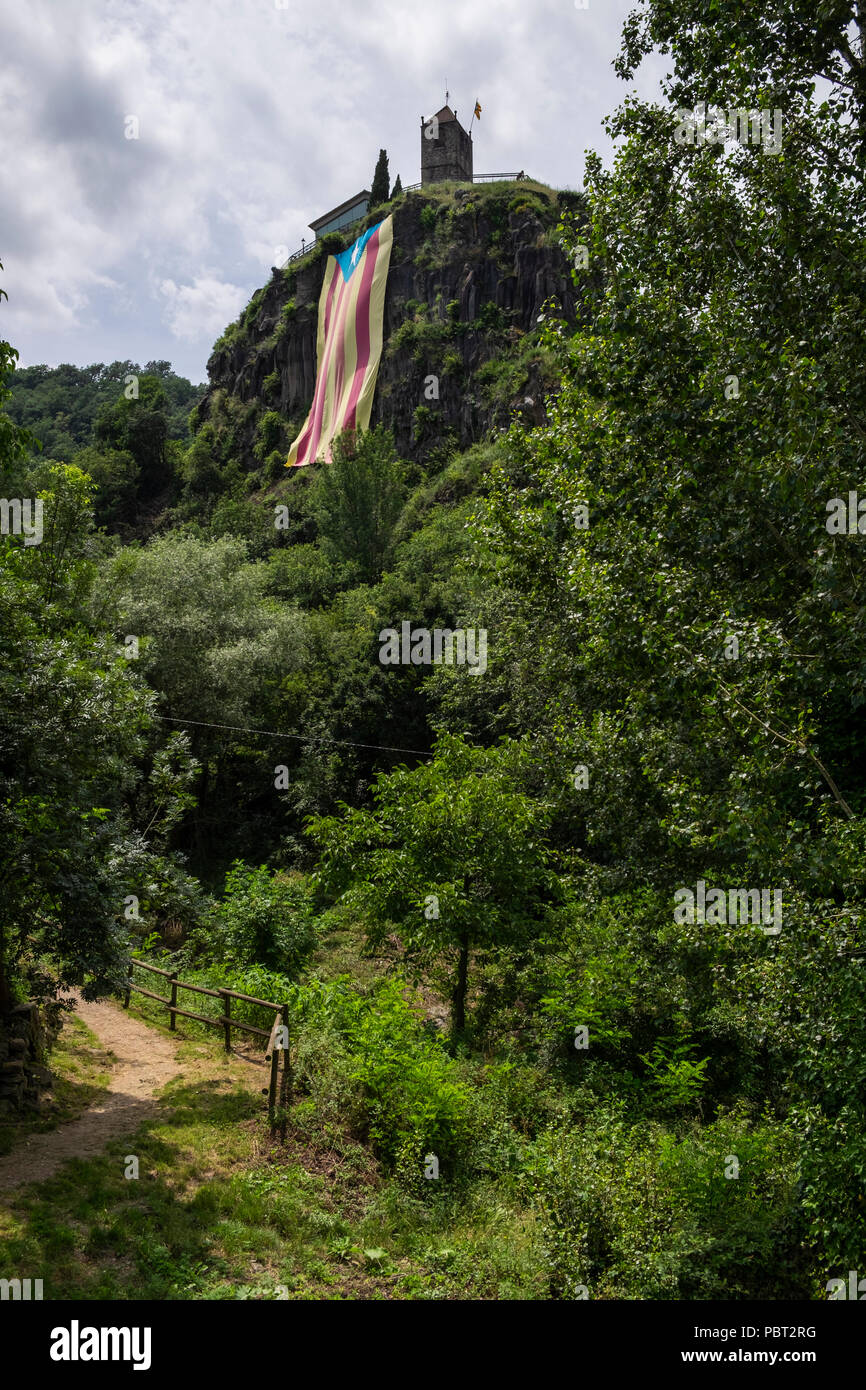 Looking up to Castellfollit de la Roca on the top of high basalt cliffs ...